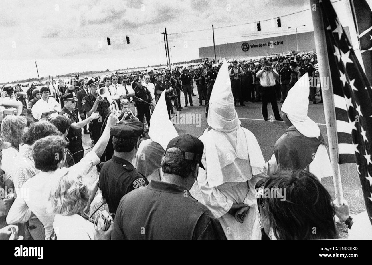 White-robed Ku Klux Klan marchers are met by scores of police and state ...