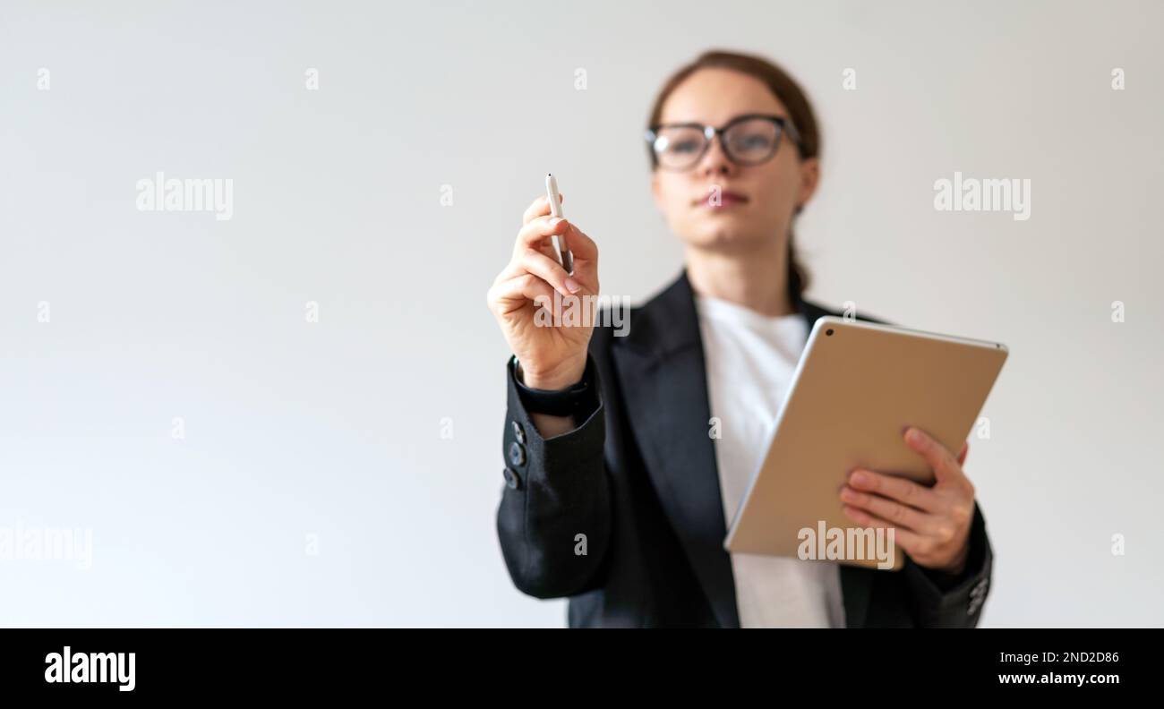 Female researcher in background works in lab using digital pen signing ...