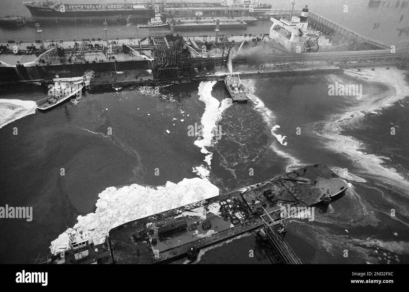 Coast Guard boats pour water onto still smoldering Exxon dock and the ...