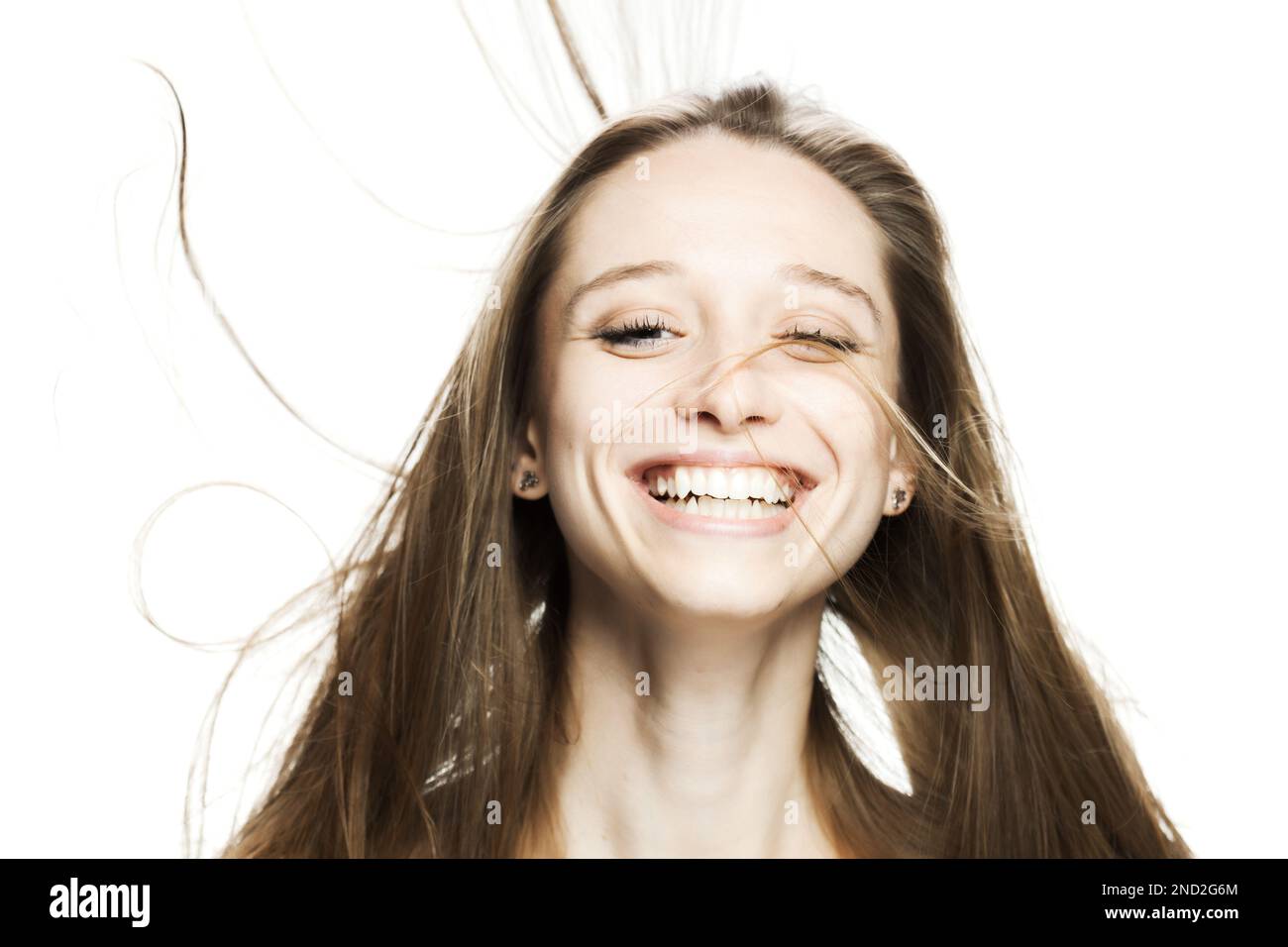 brunette girl with flowing hair in the air studio portrait against ...