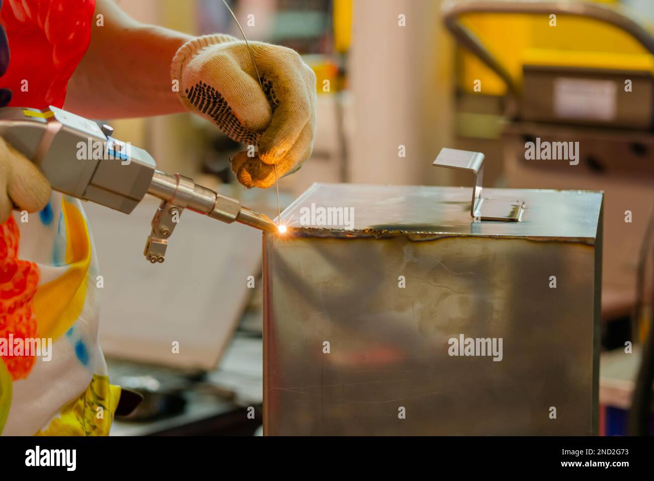 Close up: welder hands using handheld laser welding machine Stock Photo ...