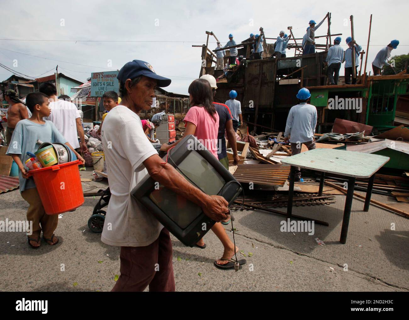 Residents carry their belongings and other household items as ...