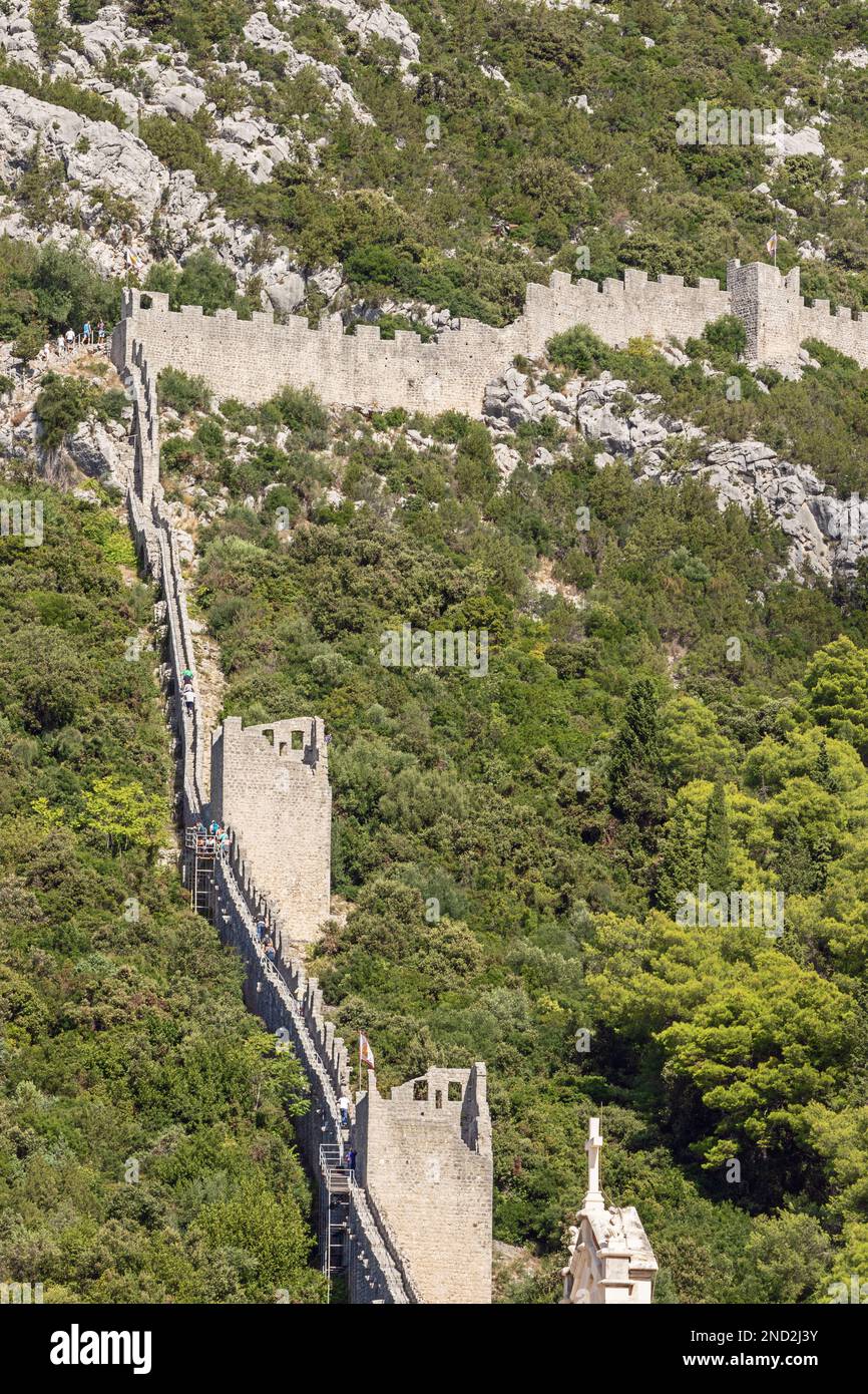 The walls of Ston winding up a hill, seen from the village Stock Photo ...