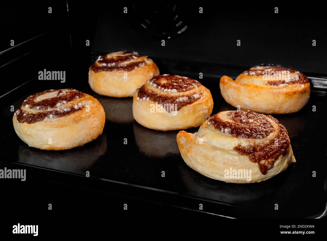 Five cinnamon buns baking and rising in electric oven Stock Photo - Alamy
