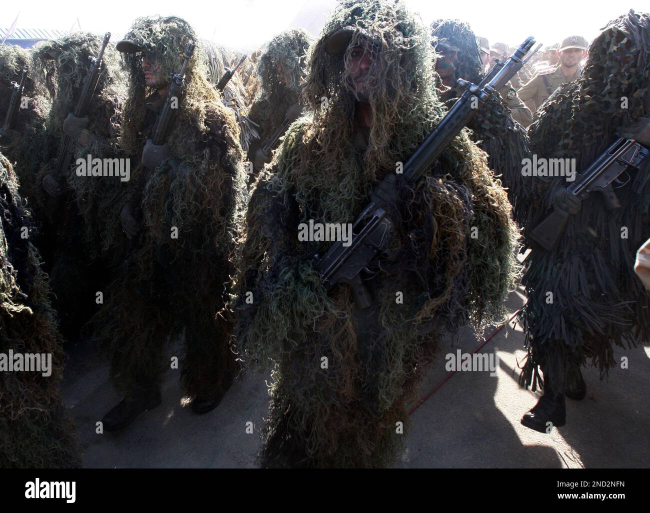 Wearing ghilli suits, Iranian army troops march during a parade marking the 30th anniversary of ...