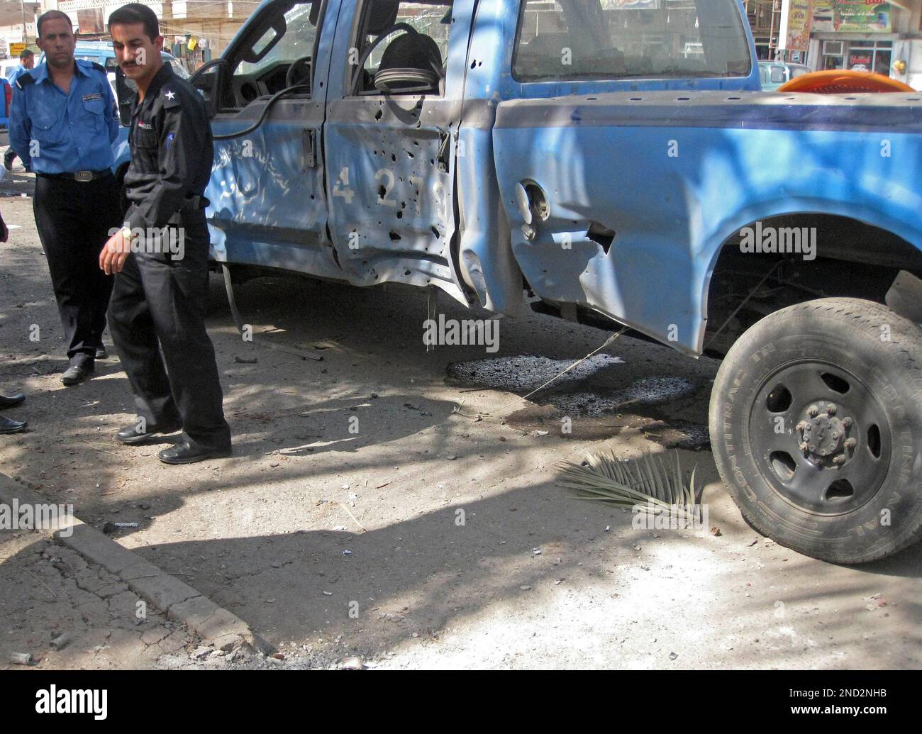 Iraqi security forces inspect the scene of a road side bomb, which ...