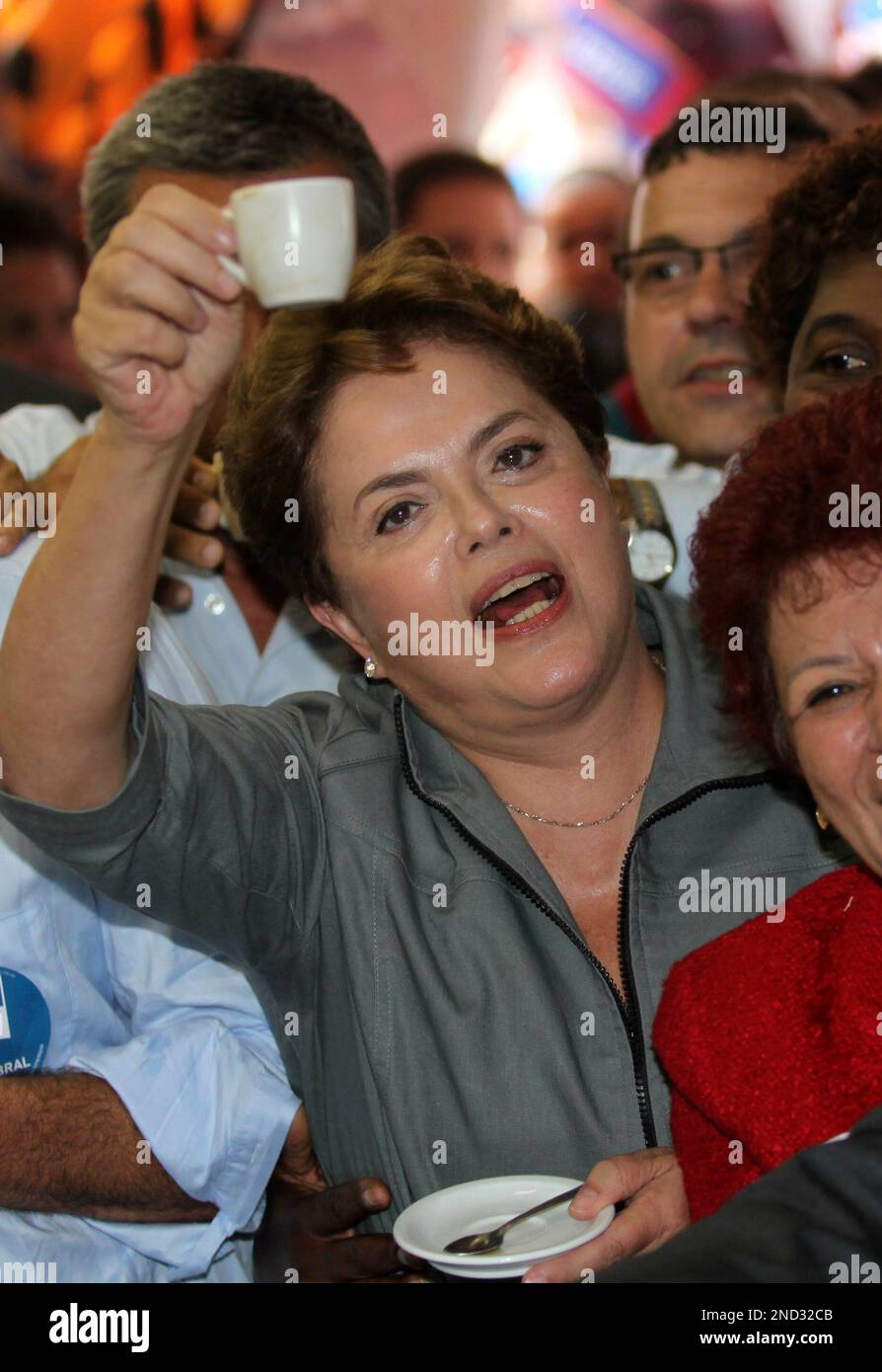Brazil's Workers party presidential candidate Dilma Rousseff holds up a ...