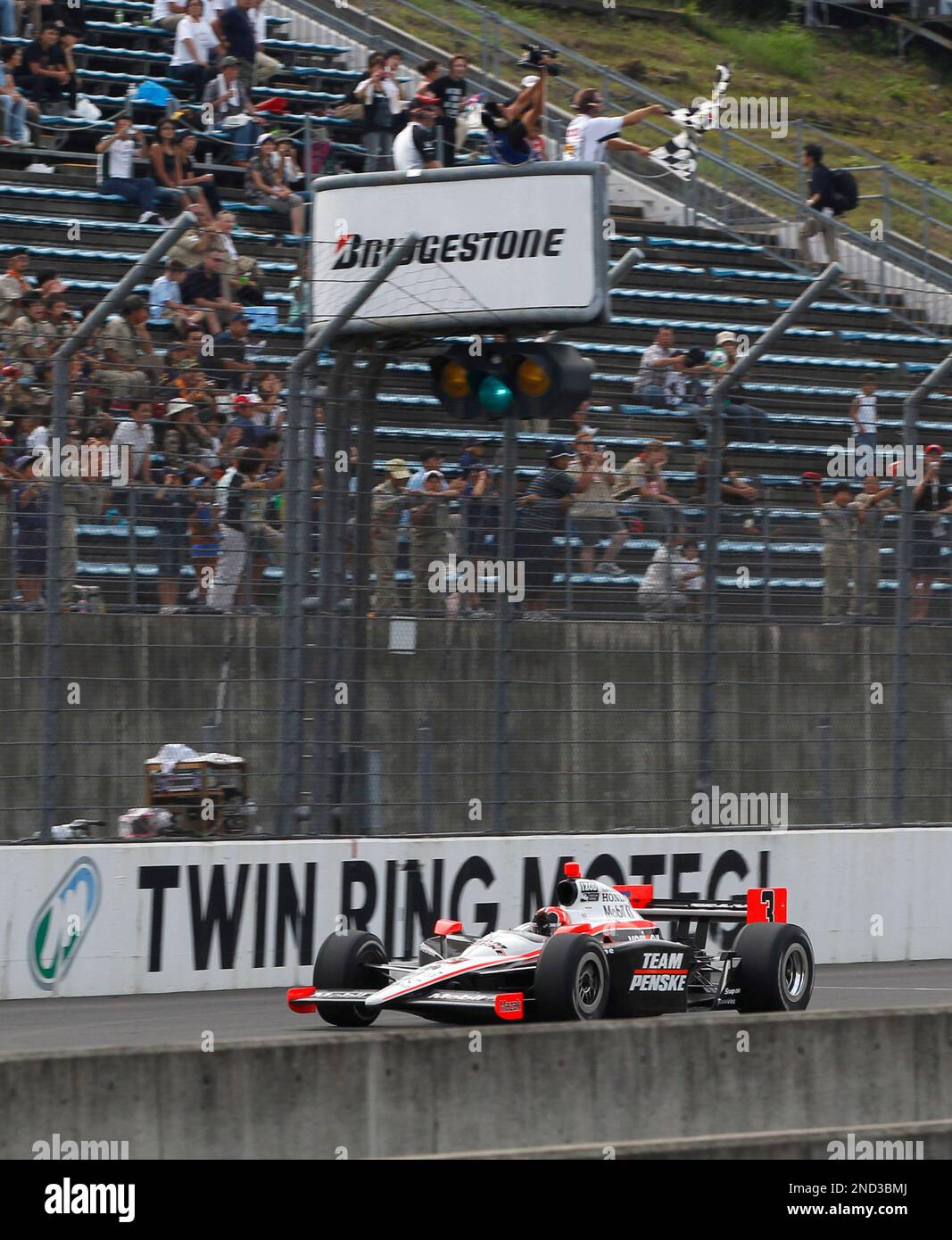 IndyCar driver Helio Castroneves of Brazil crosses the finish line to ...