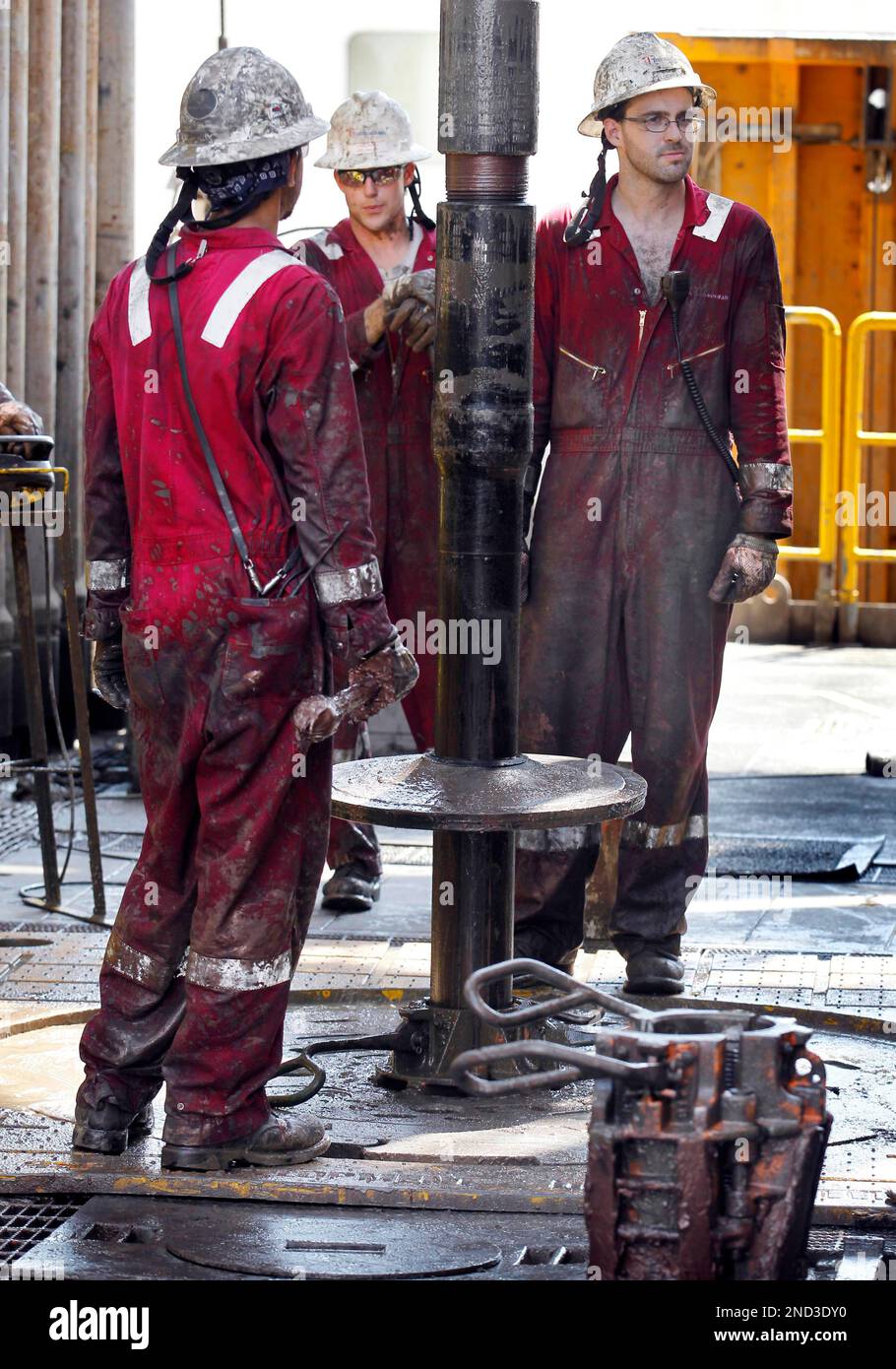 Workers remove the drill pipe on the drilling floor of Development ...