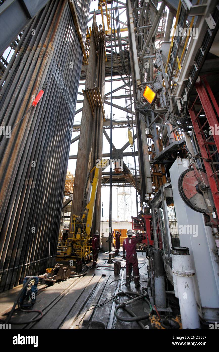 Workers remove the drill pipe on the drilling floor of Development ...