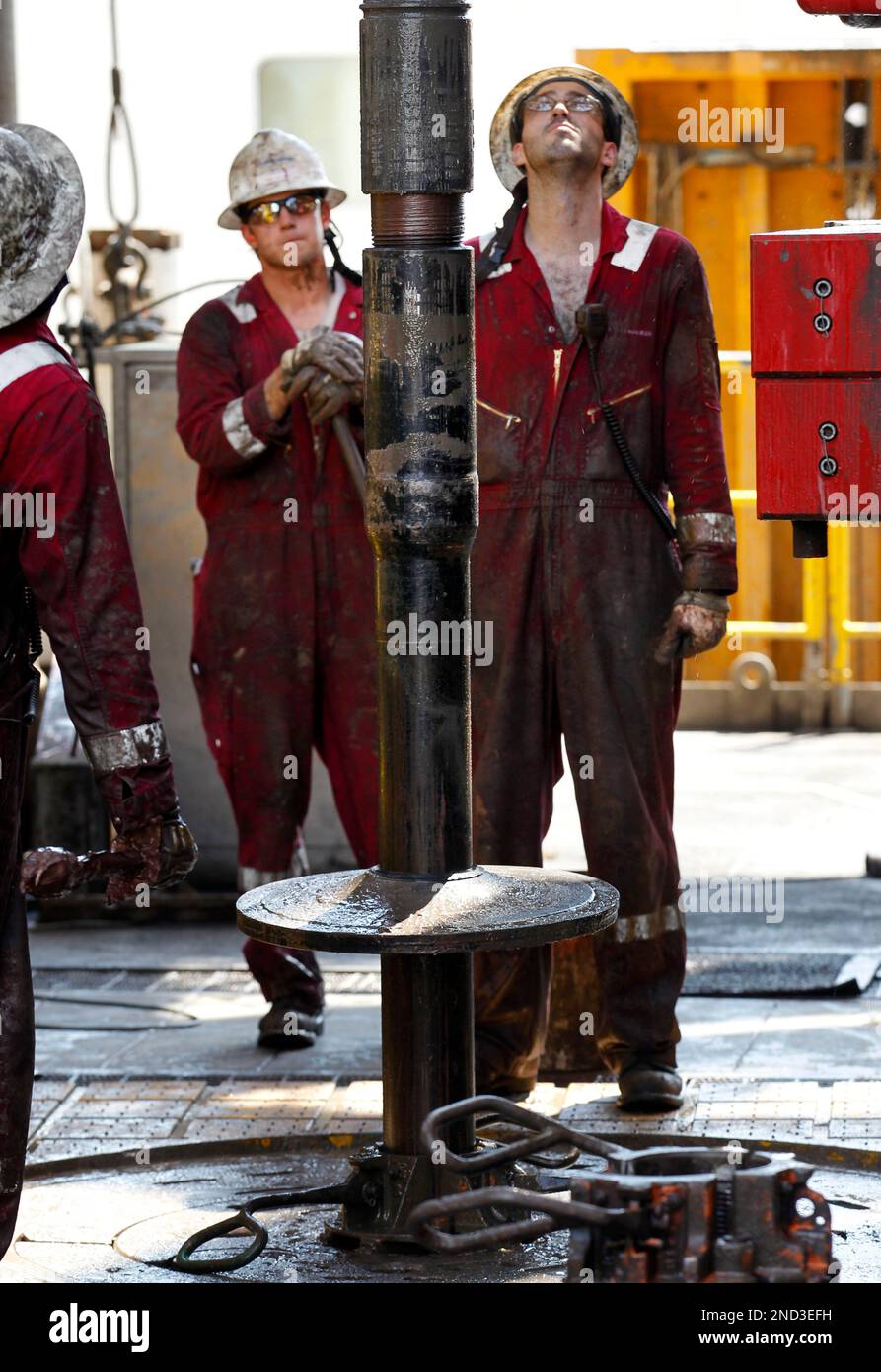 Workers remove the drill pipe on the drilling floor of Development ...