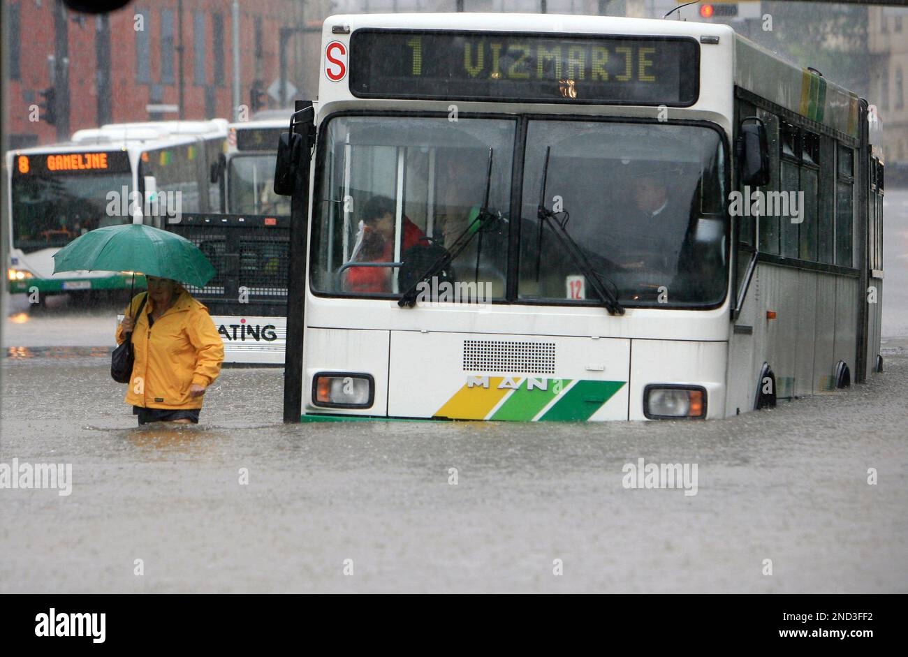 Passengers disembark a bus stuck in flooding water in Ljubljana ...