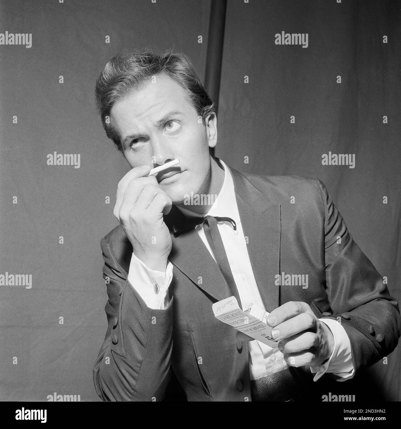 Pat Boone, the Hollywood actor and TV singer, learns the art of smoking ...