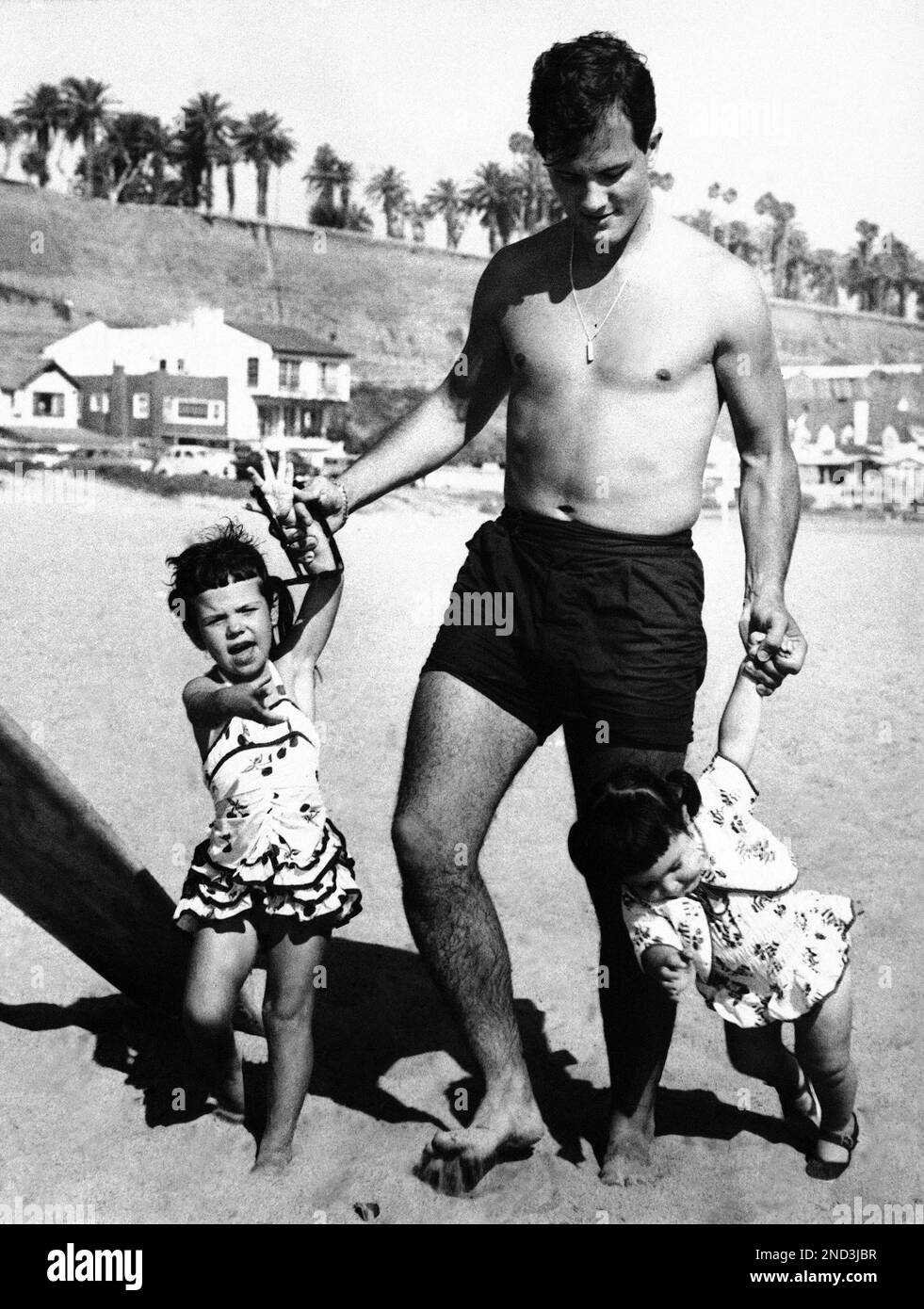 Singing star Pat Boone plays on a California beach with two of old ...