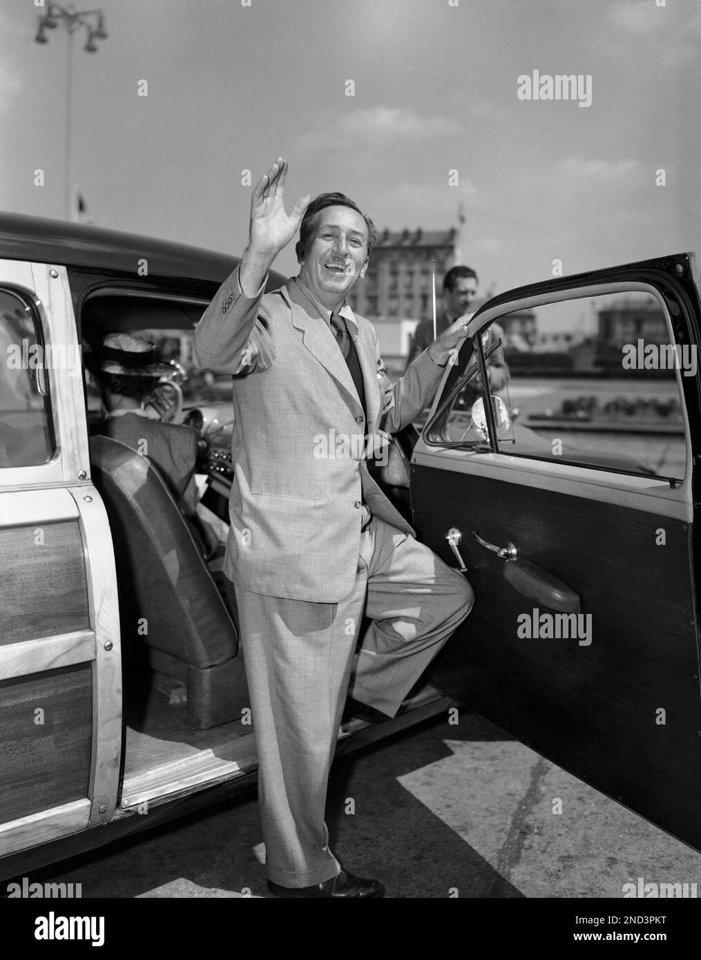 Walt Disney, famed American cartoonist and movie comics animator, waves ...