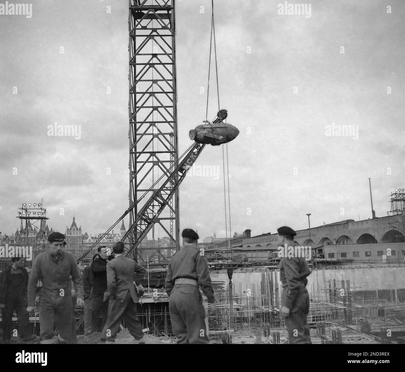 A 2,000-pound German Hermann bomb is swung from a crane as it is loaded ...