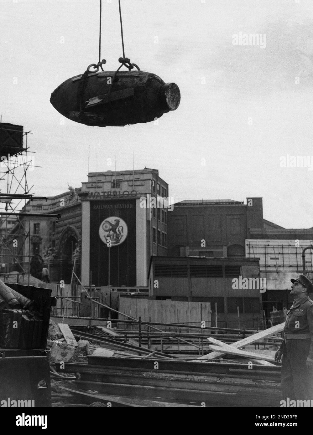 A 2,000-pound German Hermann bomb swings from a crane as it is loaded ...