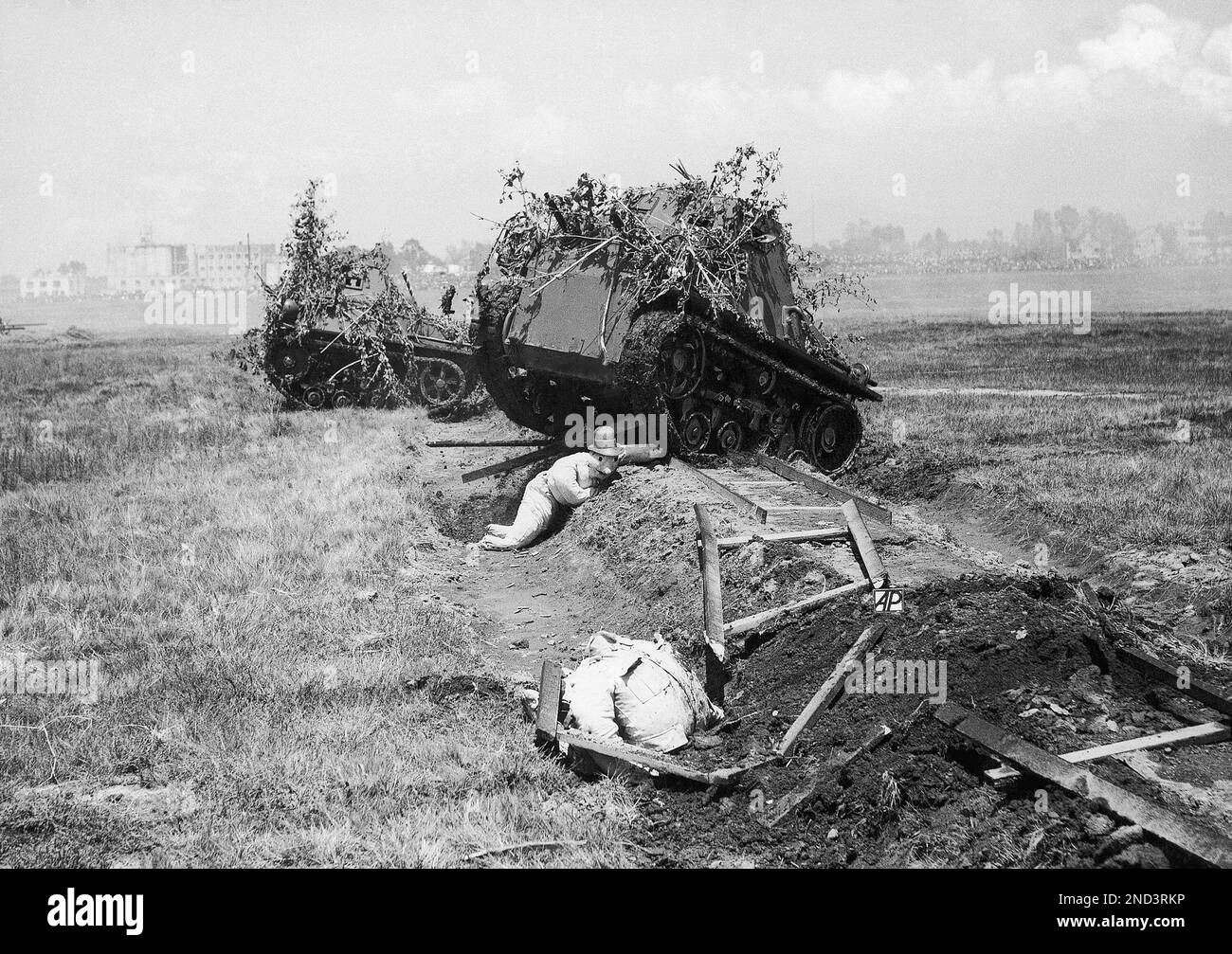 Camouflaged tanks storm across a dugout and obstacle in Mexico City ...