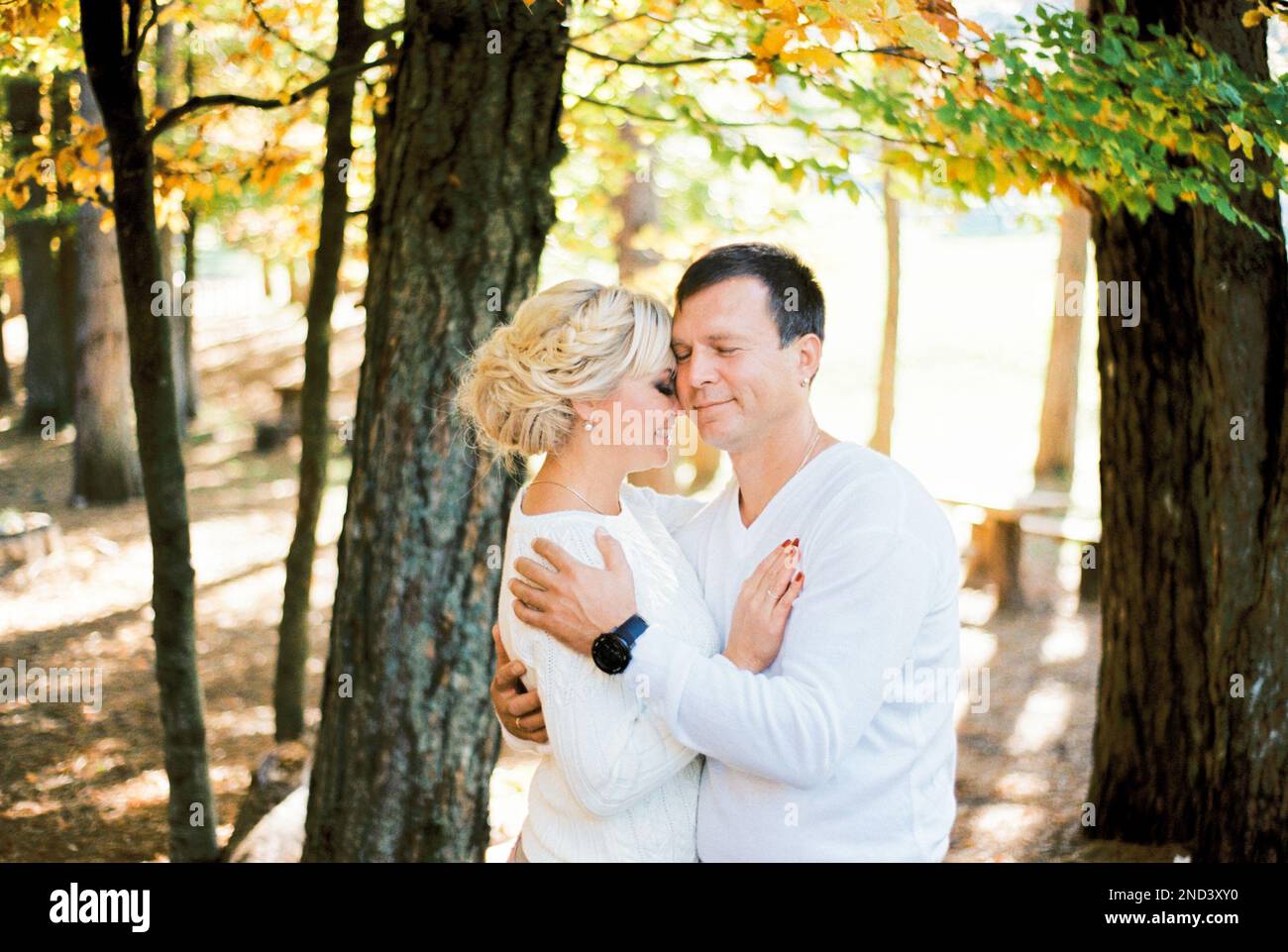 Man and woman hugging, leaning their heads against each other, standing ...