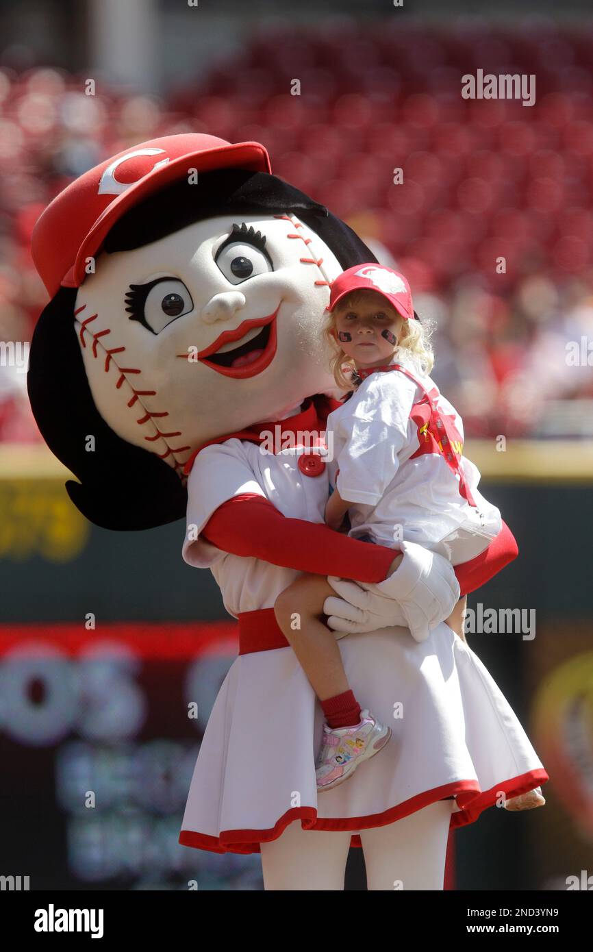 Cincinnati Reds mascot Rosie Red holds a young fan during a baseball ...