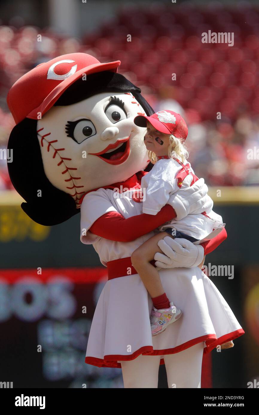Cincinnati Reds mascot Rosie Red holds a young fan during a baseball ...