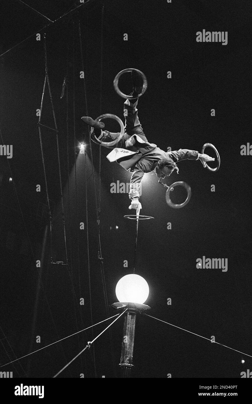 Balancing himself with a cane on a lighted globe, Unus, entertainer ...