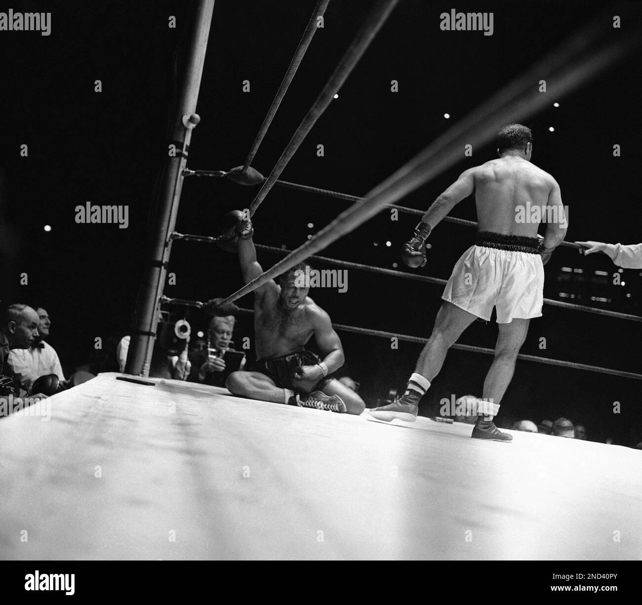 Challenger Archie Moore, down in his corner and one glove on the rope ...