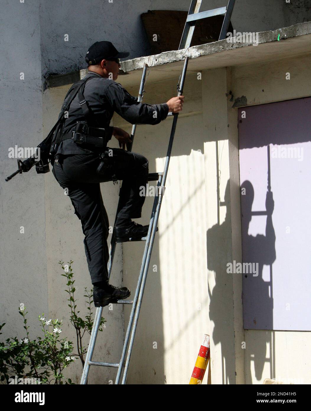 A SWAT member of the Philippine National Police climbs up to patrol the ...