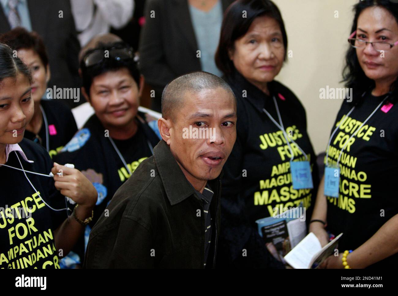 Witness Lakmudin Saliao prepares to take his seat with the relatives of ...