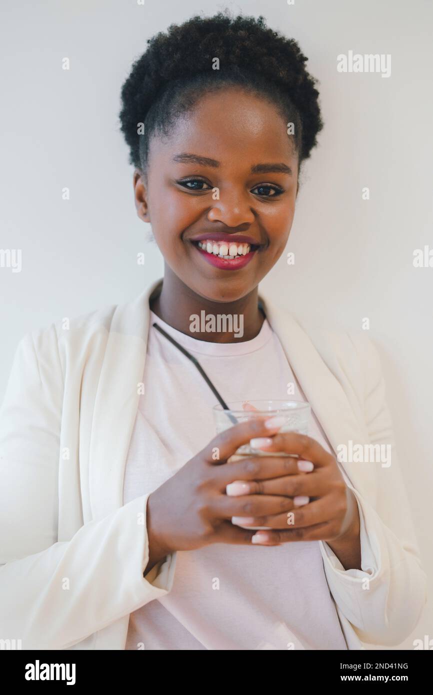 Happy woman drinking from a glass through a straw iced coffee during ...