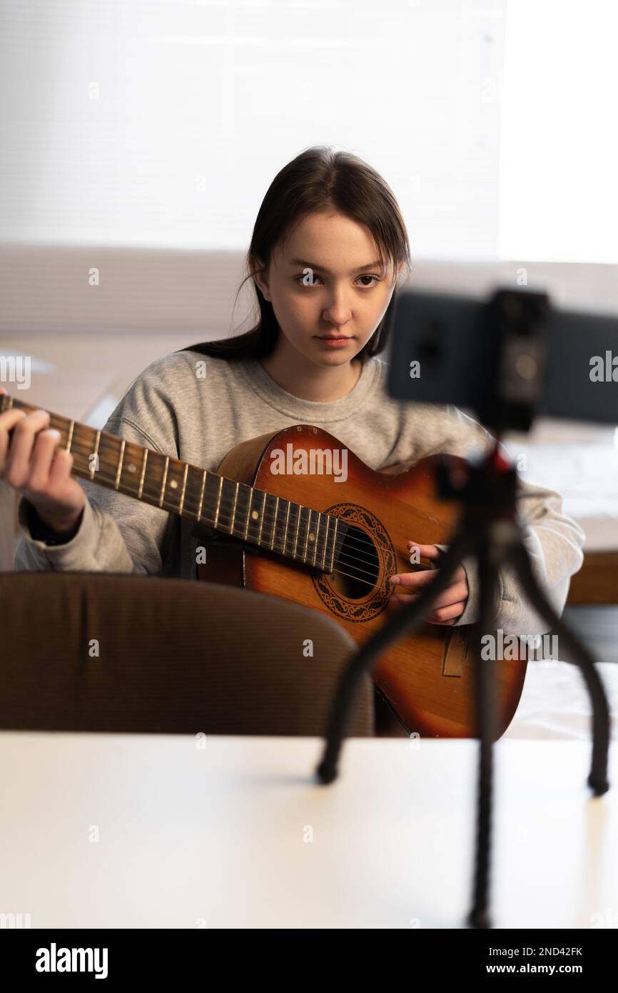 Young asian female artist blogger playing on guitar shooting music ...