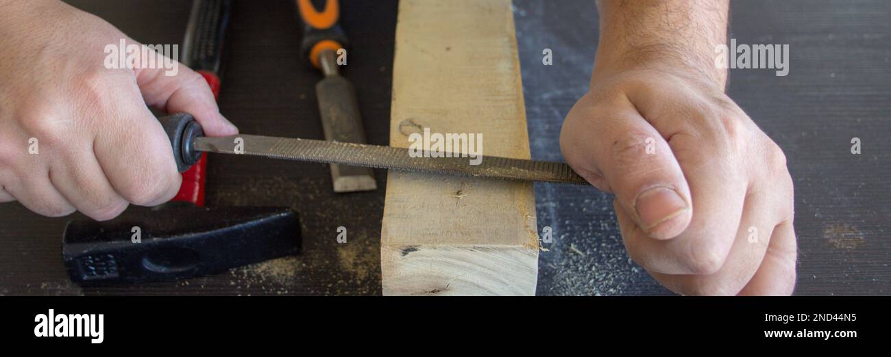 Image of the hands of a carpenter craftsman who smoothes a piece of ...