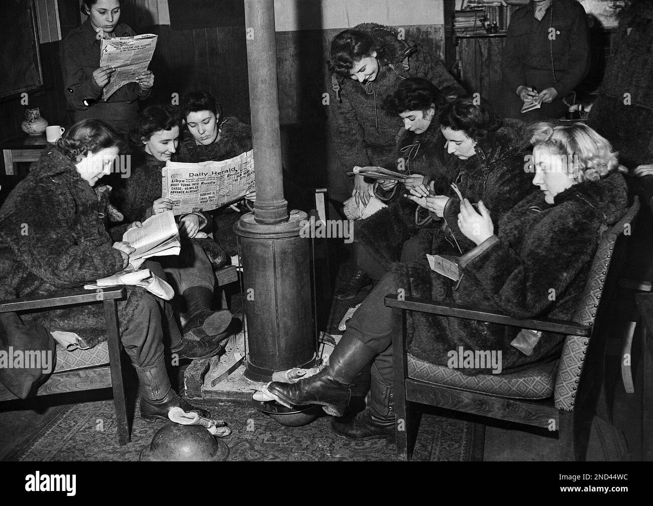 The ack-ack A.T.S. girls, wearing their thick, teddy bear, suits, sit ...