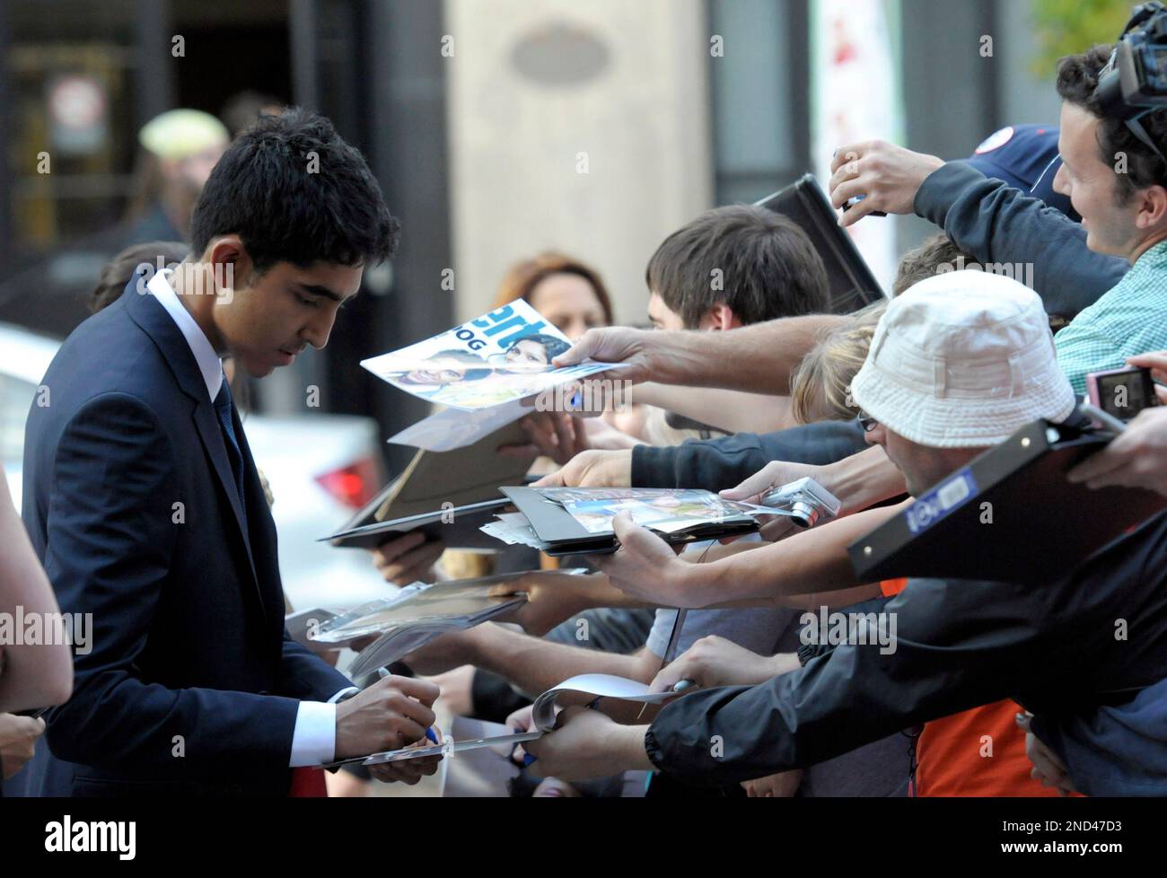 Actor Dev Patel arrives and autographs items for fans at the premiere ...
