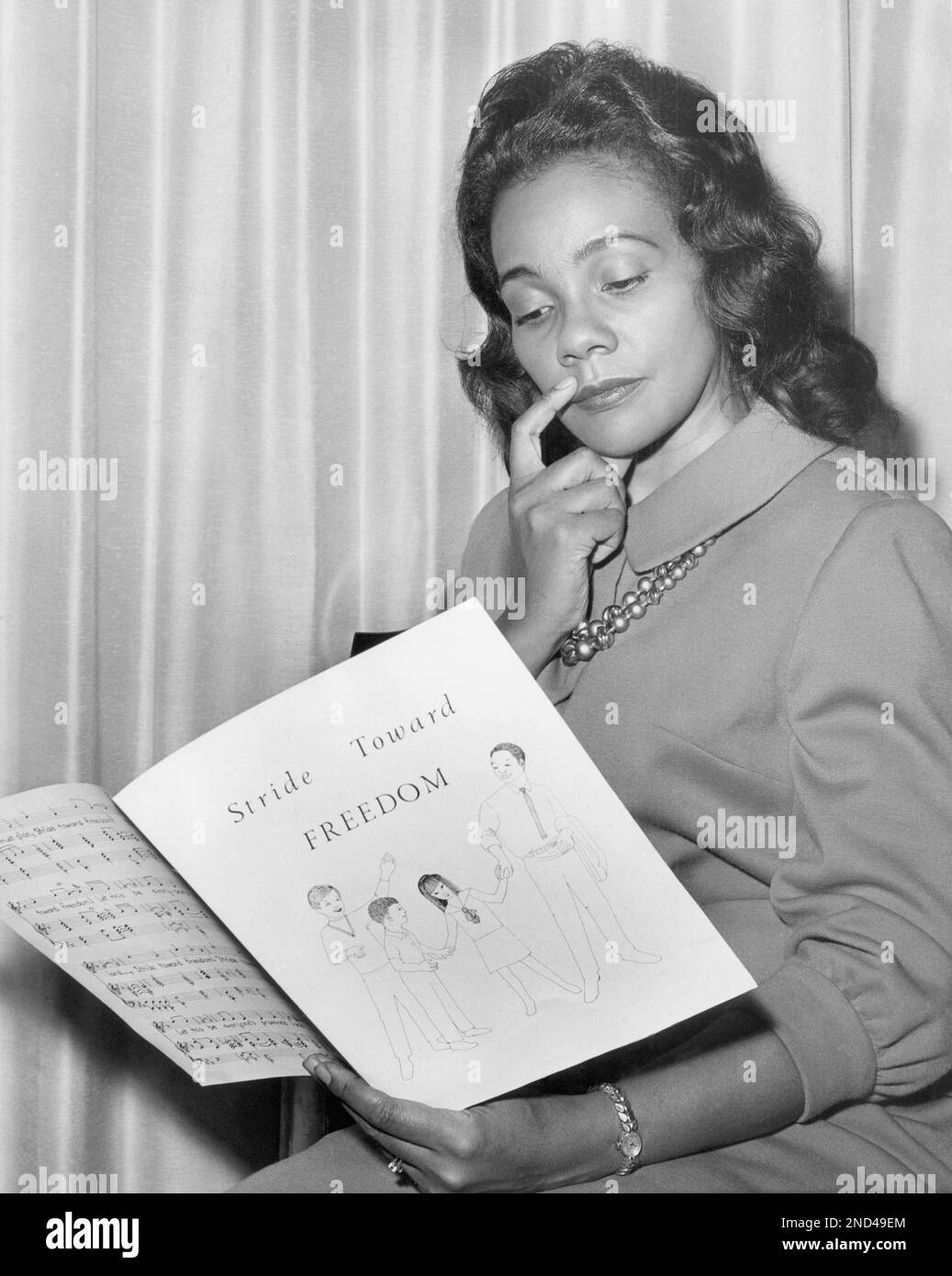 Coretta Scott King, wife of Dr. Martin Luther King Jr., studies one of ...