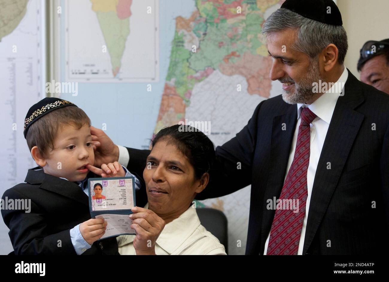 Sandra Samuel, center, holds up her Israeli identification card as she ...