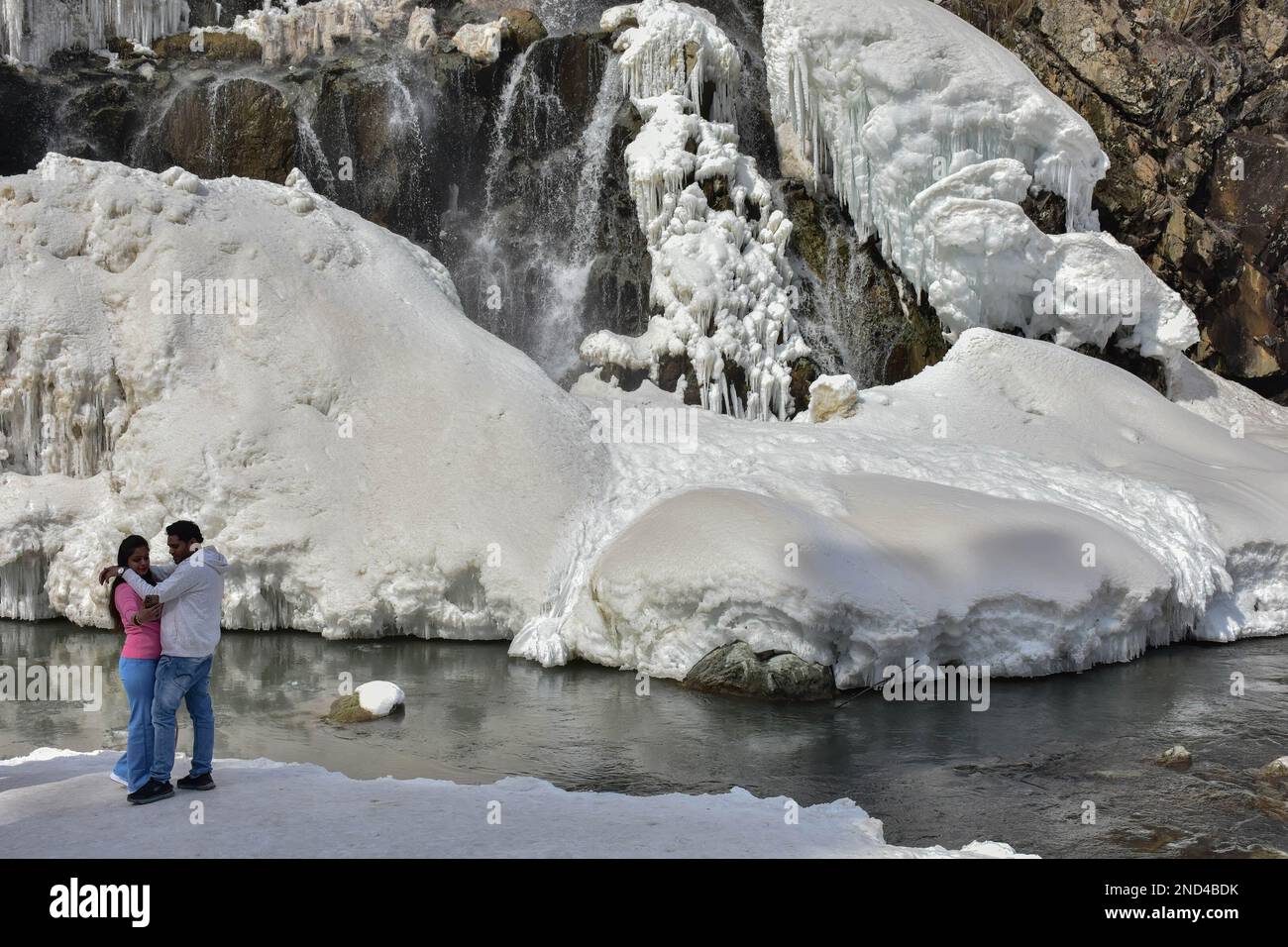 An Indian couple take selfie near the frozen Drung waterfall on a sunny ...