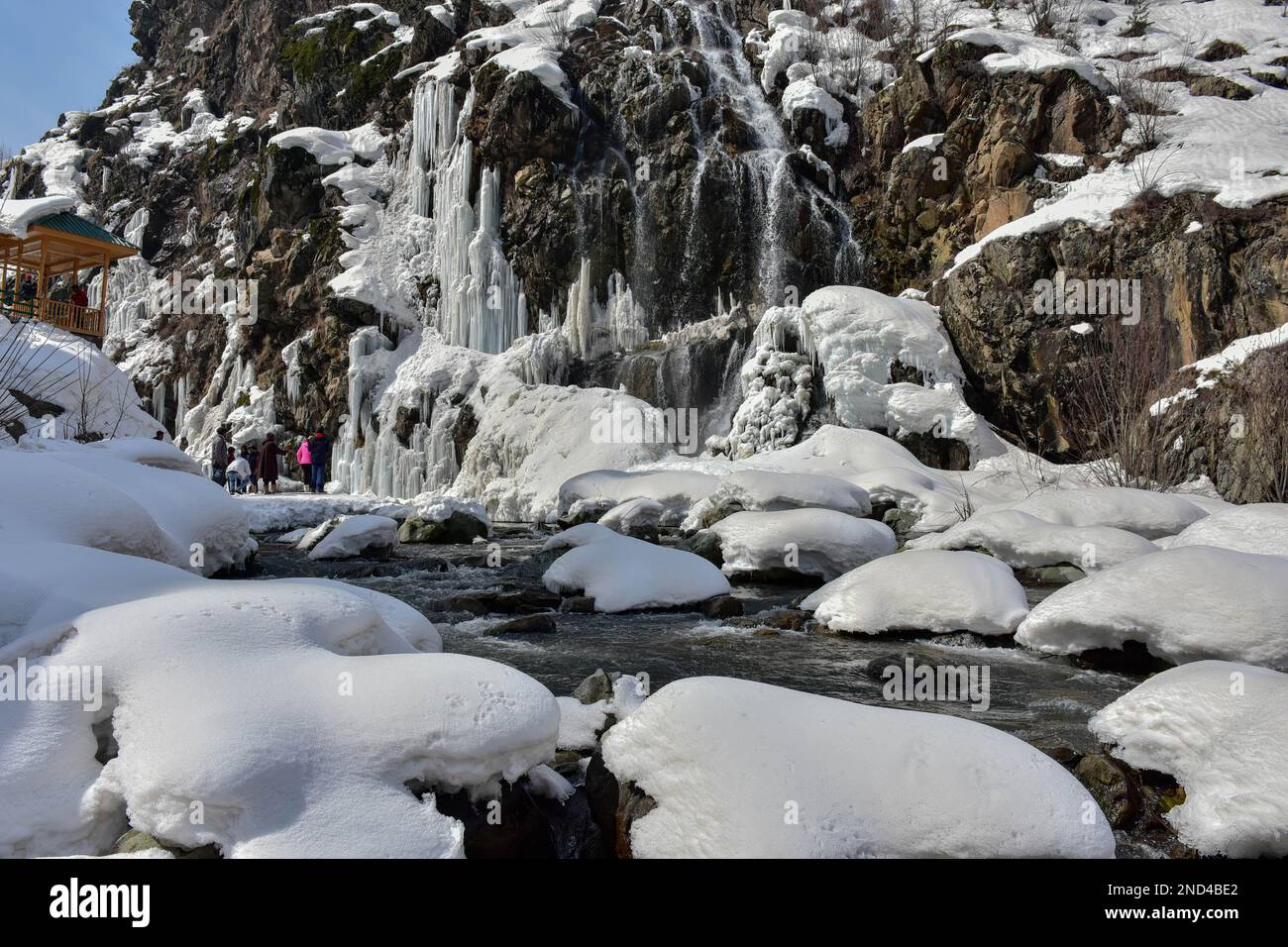 Visitors explore the frozen Drung waterfall on a sunny winter day in ...