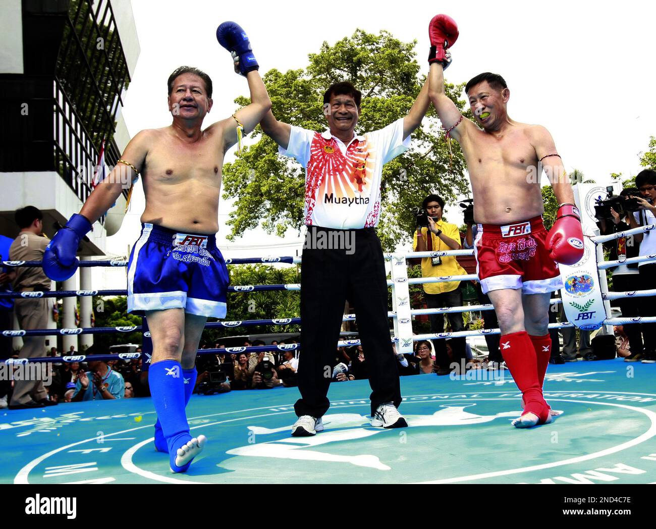 A referee raises the arms of Thai boxers and senators Payap Tongchuen ...