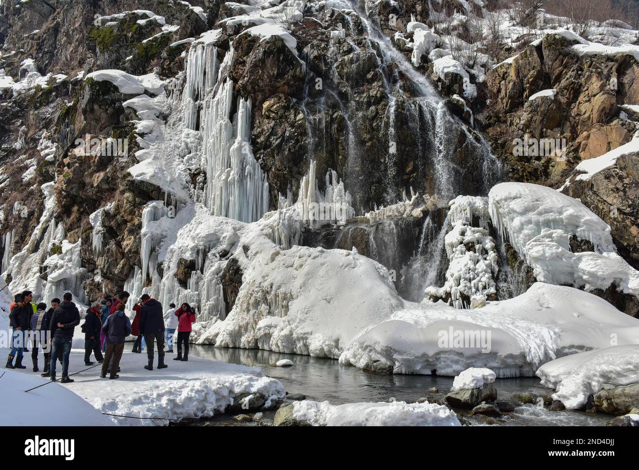 Visitors explore the frozen Drung waterfall on a sunny winter day in Tangmarg, about 40kms from ...