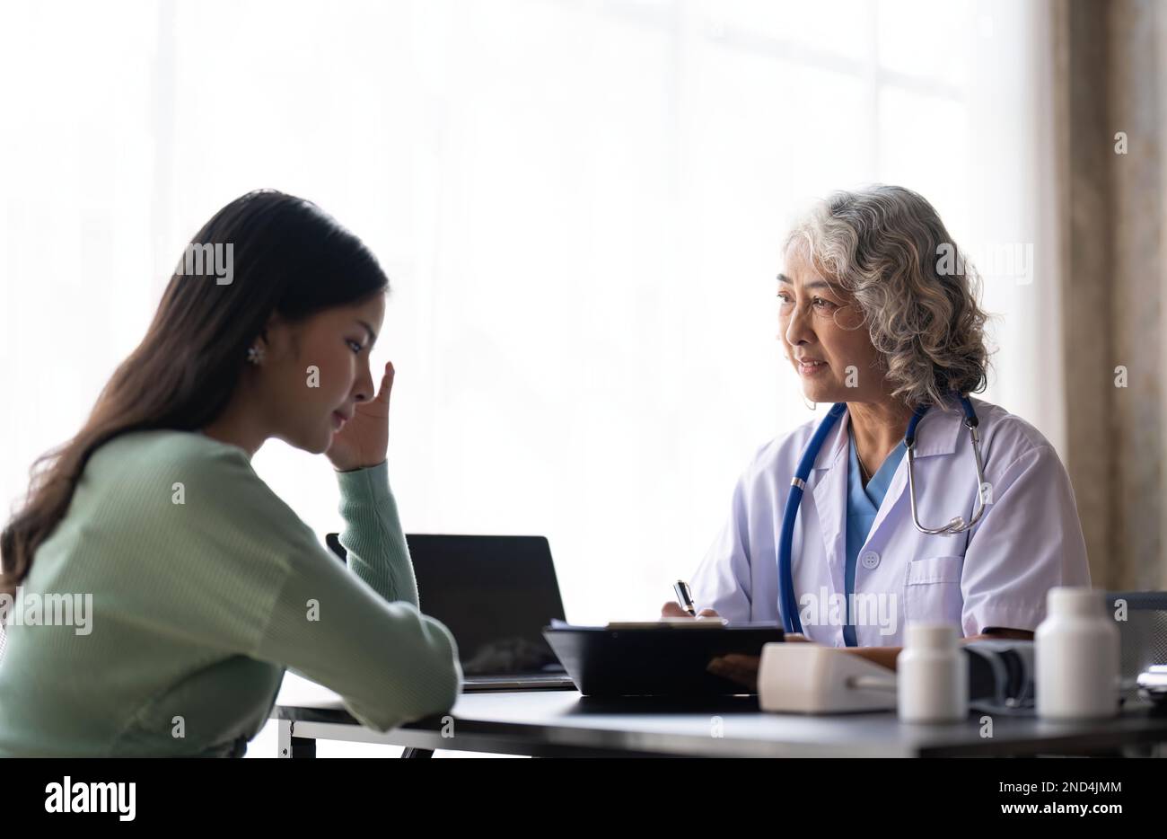 Woman senior doctor is Reading Medical History of Female Patient and ...