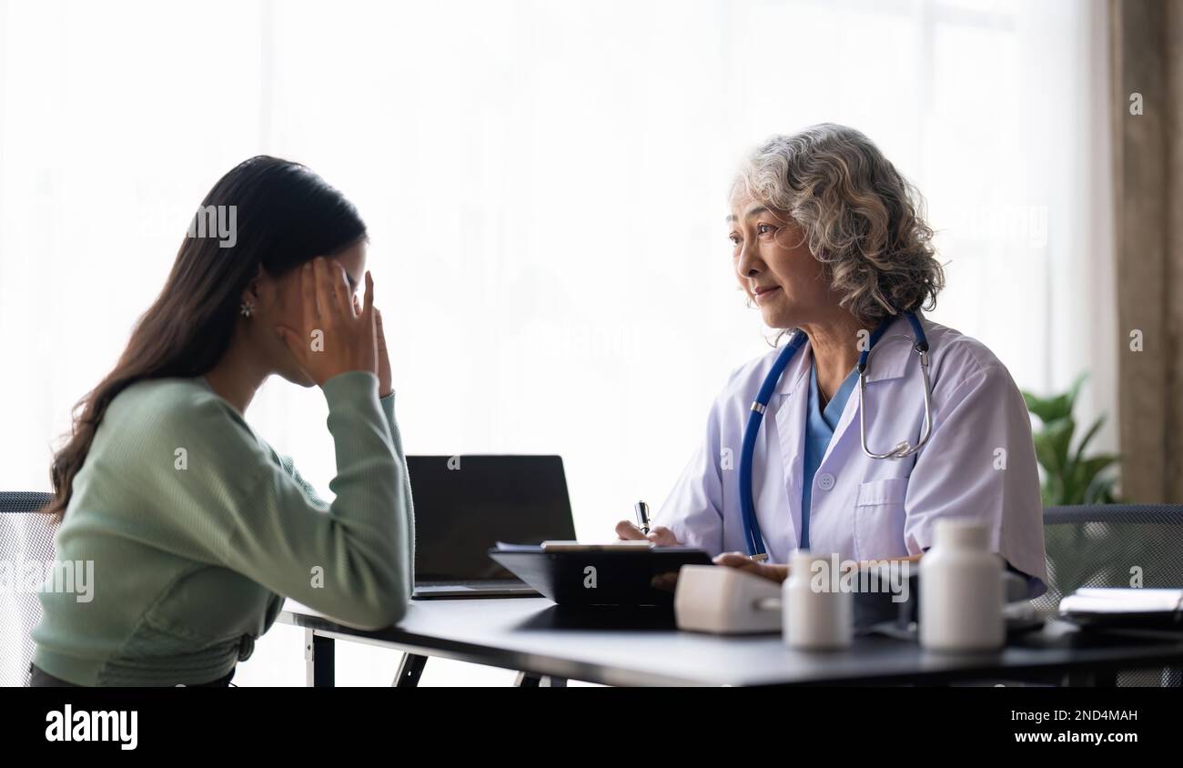 Woman senior doctor is Reading Medical History of Female Patient and ...
