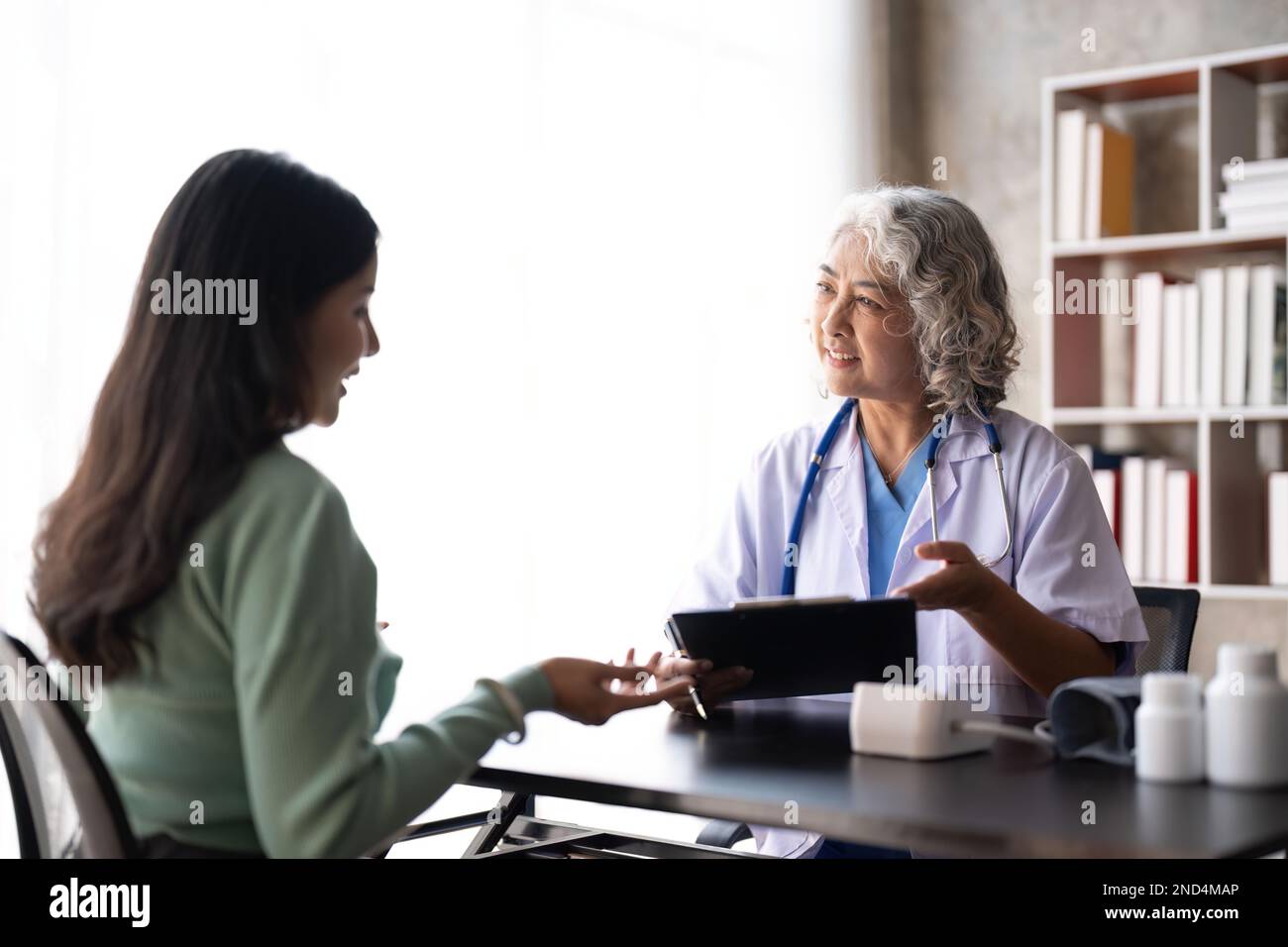 Woman senior doctor is Reading Medical History of Female Patient and ...