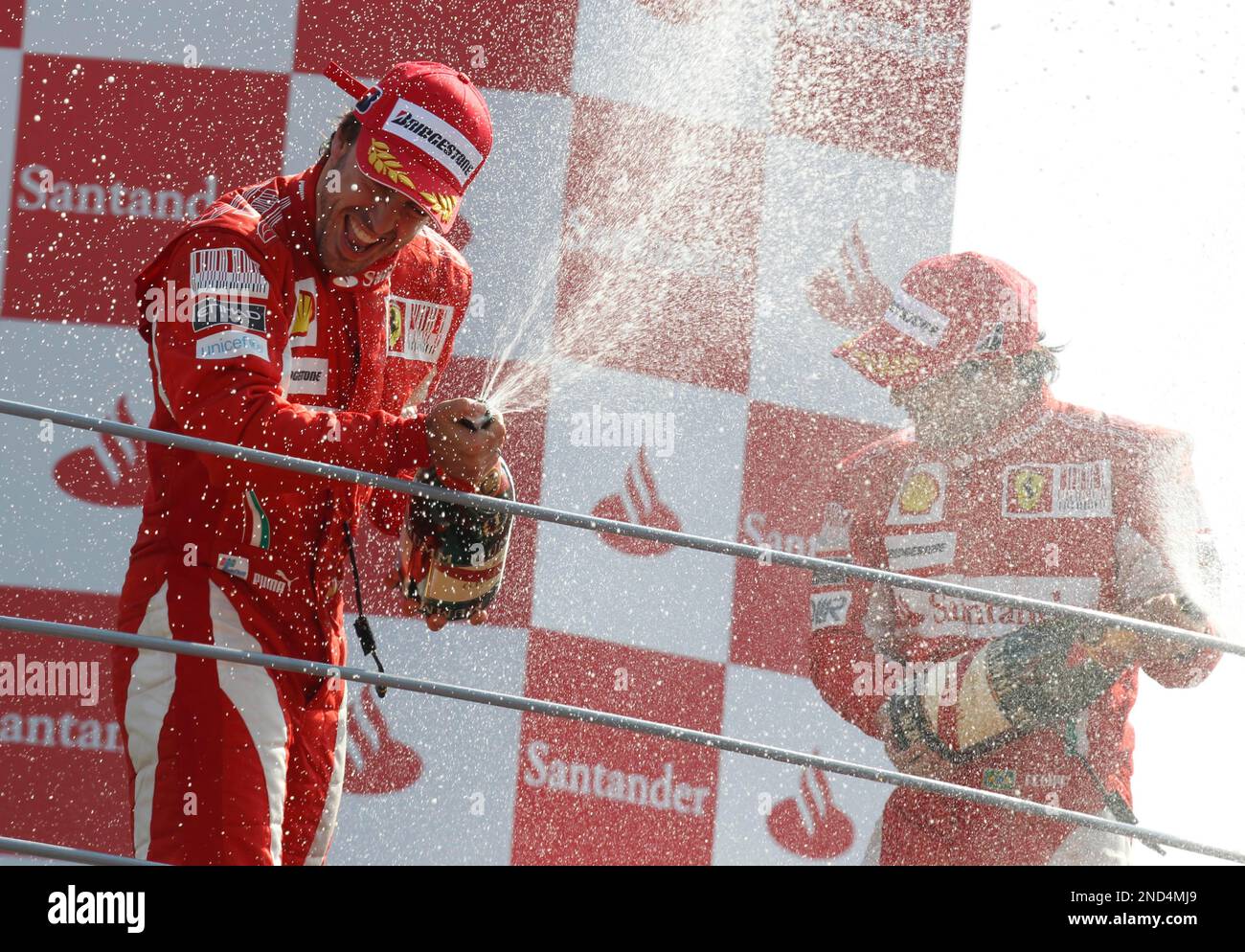 Ferrari driver Fernando Alonso of Spain, left, sprays champagne on the ...