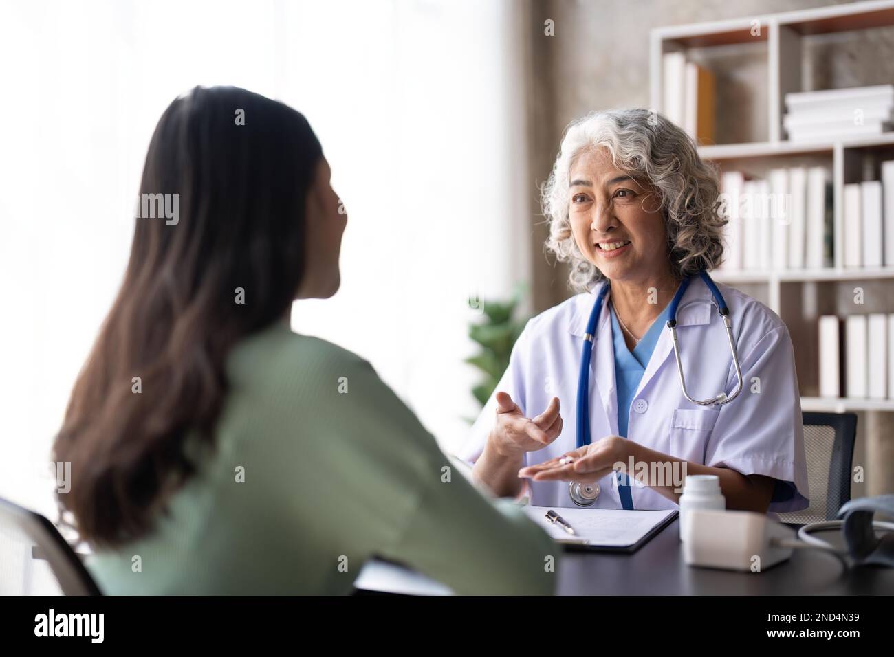 Woman senior doctor is Reading Medical History of Female Patient and ...