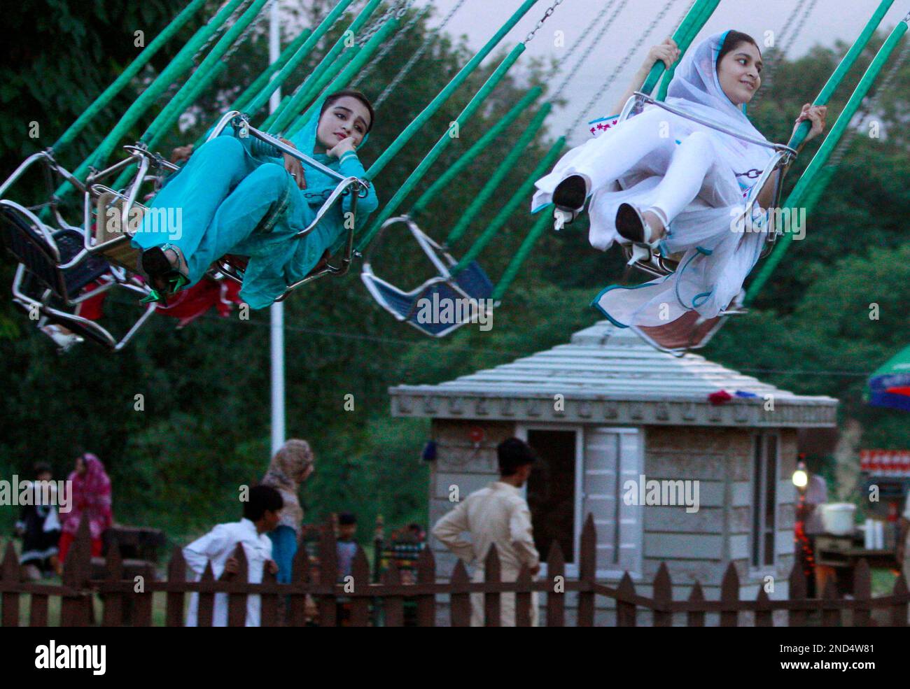 Pakistani Muslim women ride at a carnival as they celebrate Eid al-Fitr ...