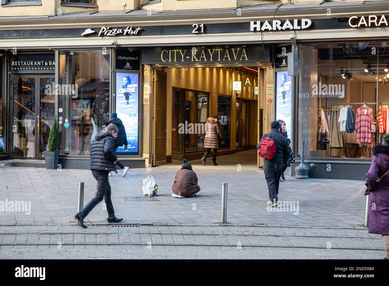 Elderly man sitting on the sidewalk begging in front of City-käytävä in ... Elderly man sitting on the sidewalk begging in front of City-käytävä in ...