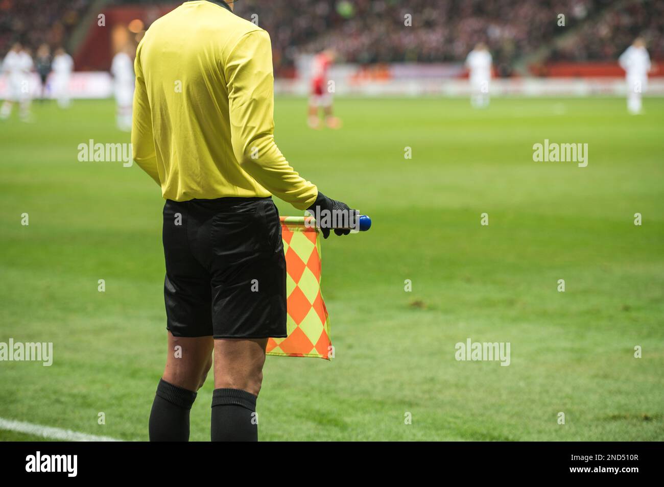 Soccer touchline referee with the flag during match at the football ...