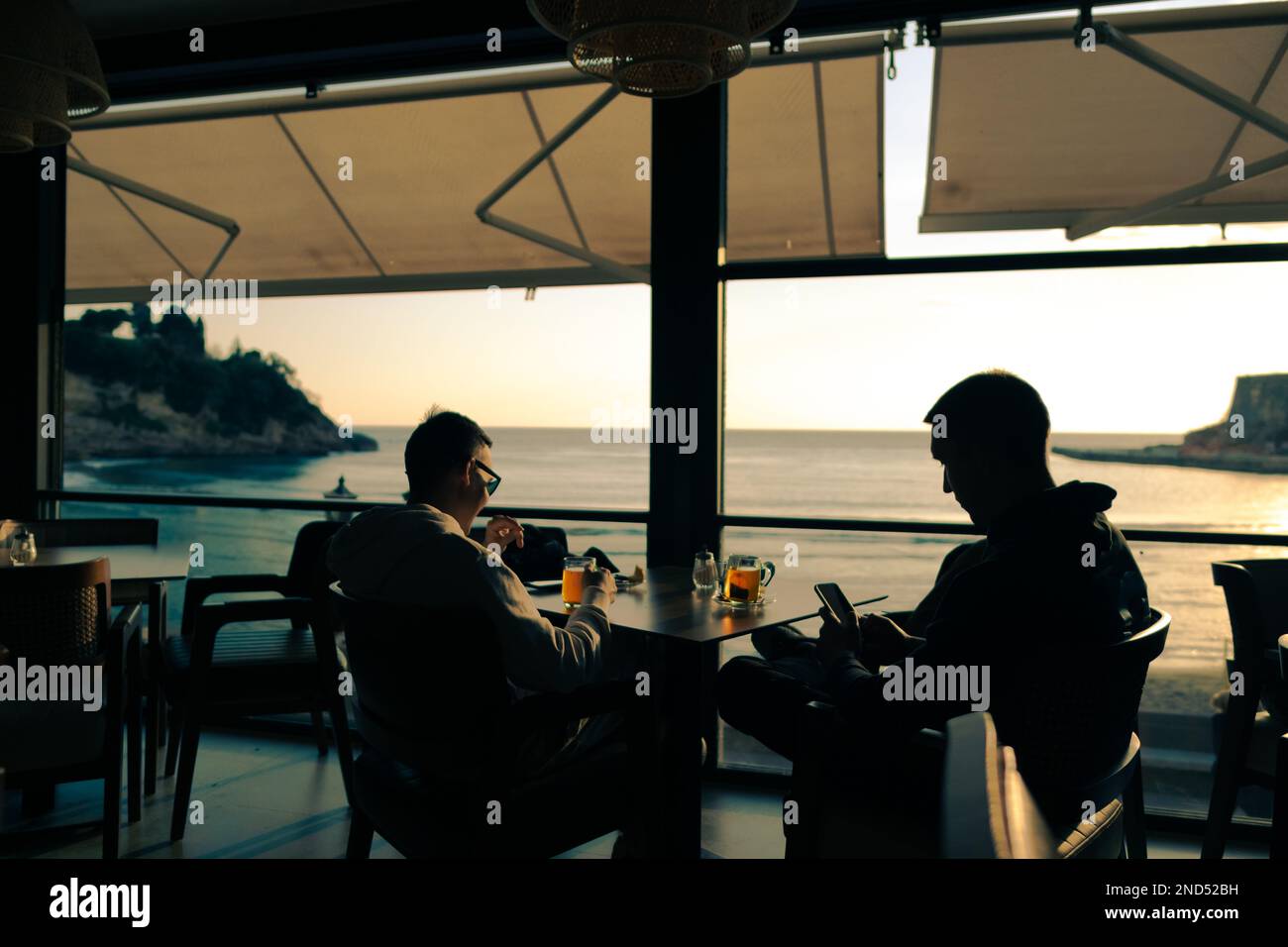 Two friends in a restaurant by the sea Stock Photo - Alamy