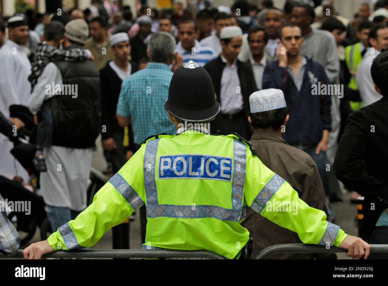 A British police officer watches as British Muslims exit London's ...